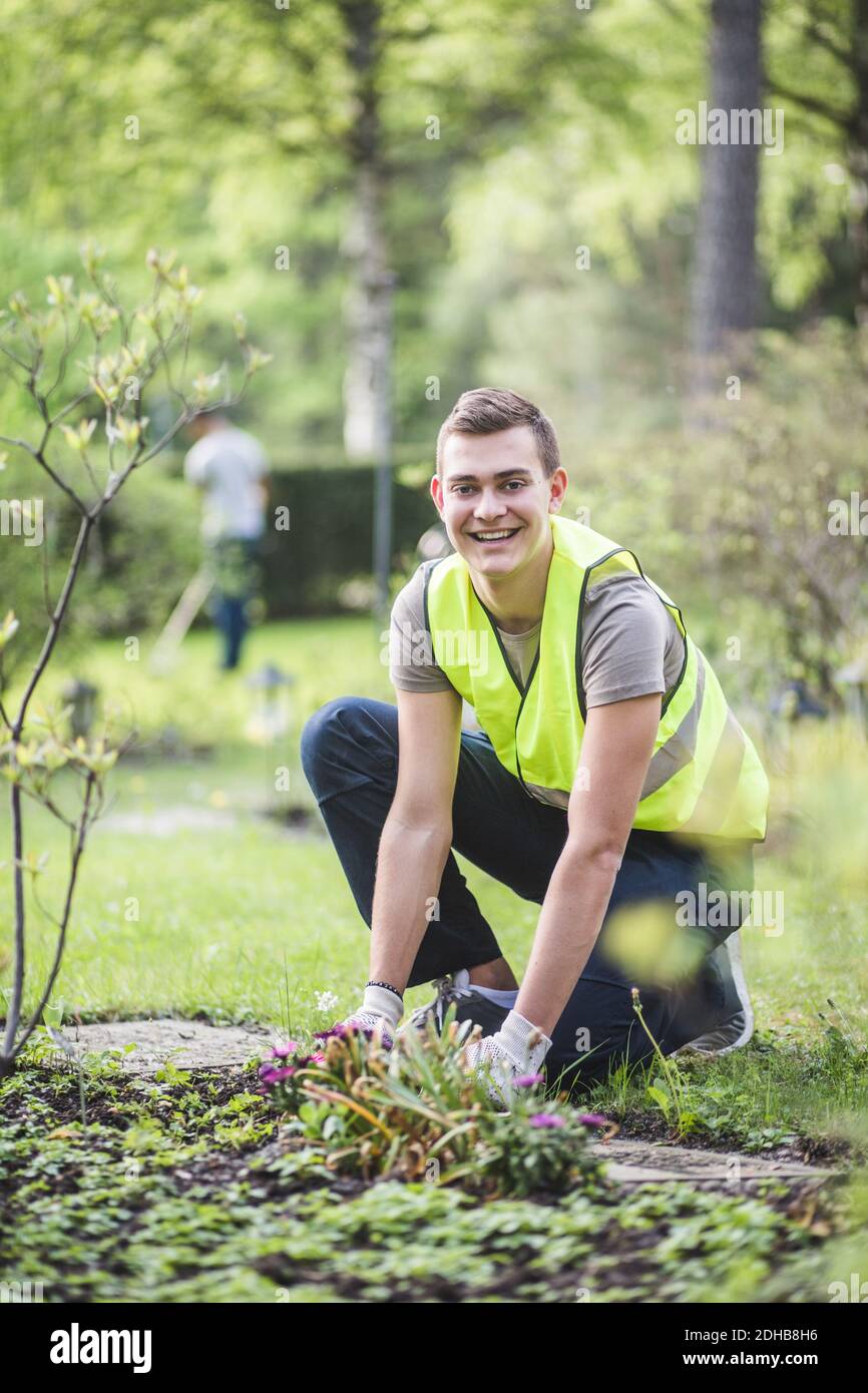 Full length portrait of smiling young man planting at garden Stock ...