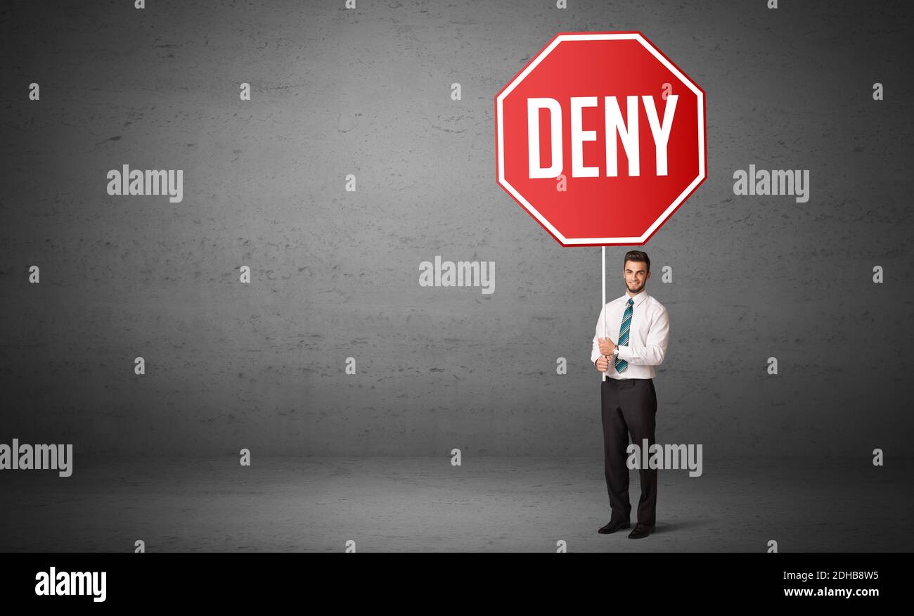 Young business person holding road sign with DENY inscription, new ...