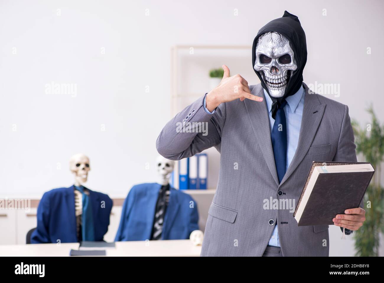 Funny business meeting with devil and skeletons Stock Photo - Alamy