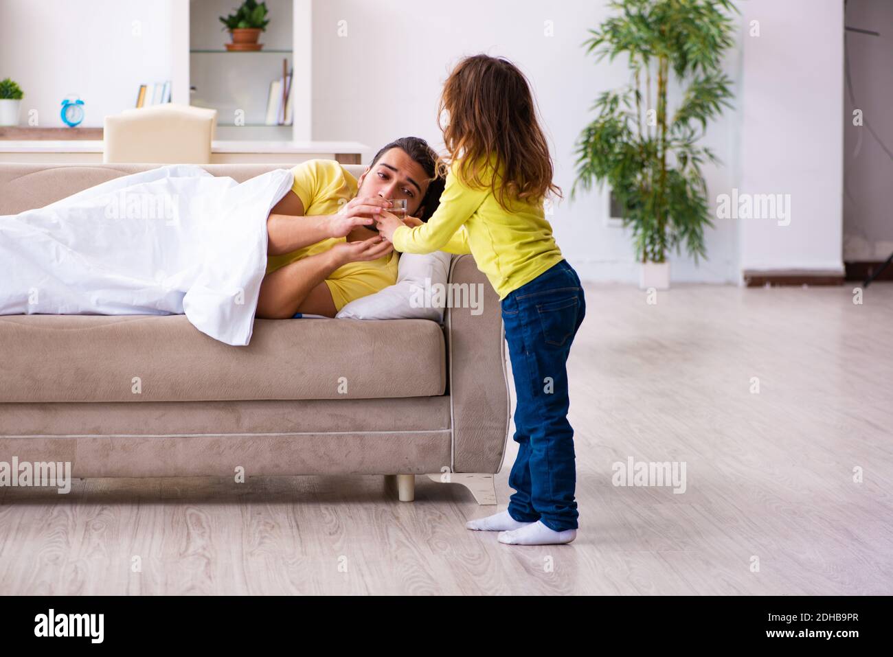 Small girl looking after her sick father Stock Photo - Alamy