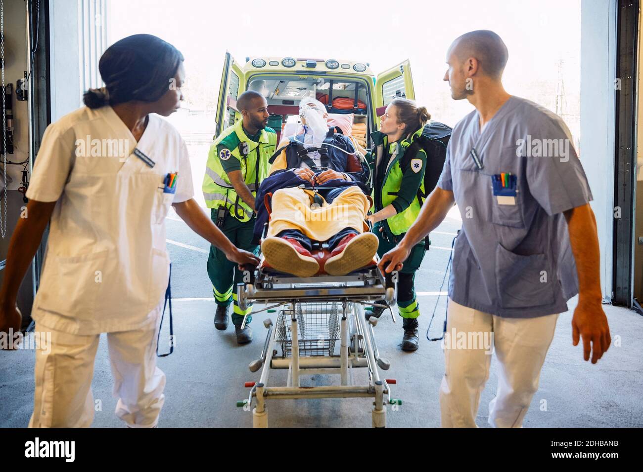 Healthcare workers pushing patient on gurney in hospital Stock Photo ...