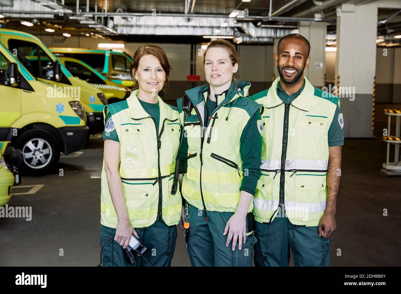 Portrait of confident paramedics standing against ambulance in parking ...