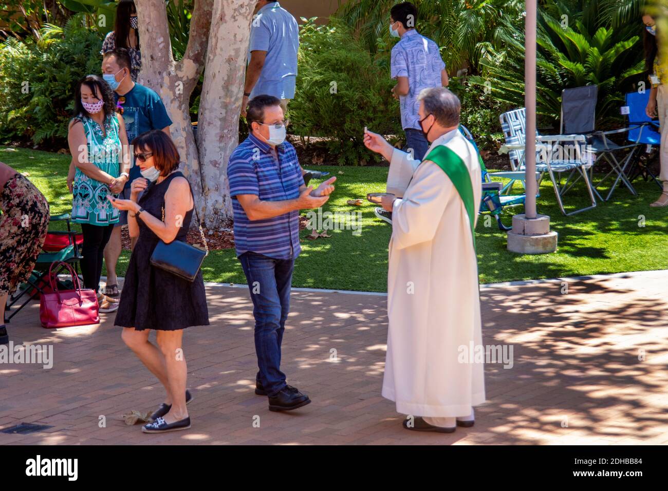 Masked due to the coronavirus pandemic, multiethnic parishioners of a ...