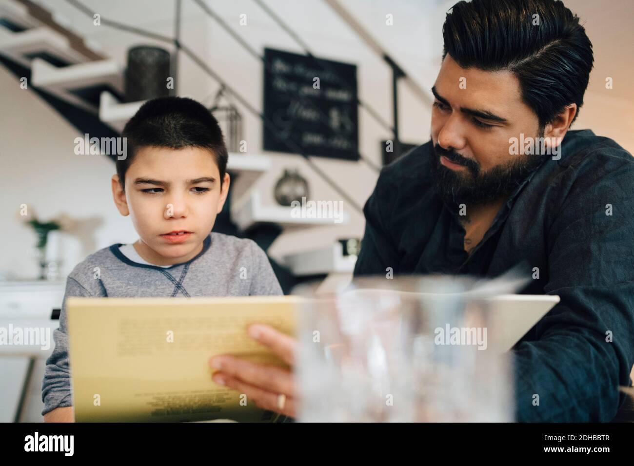 Father teaching autistic son while sitting in living room at home Stock ...