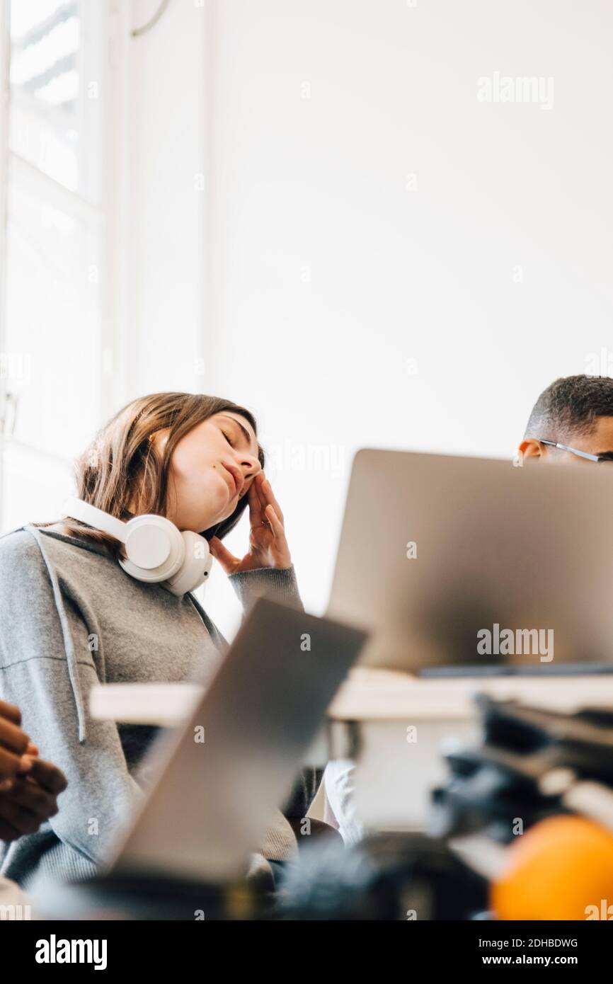 Exhausted female computer hacker sitting at desk in office Stock Photo ...