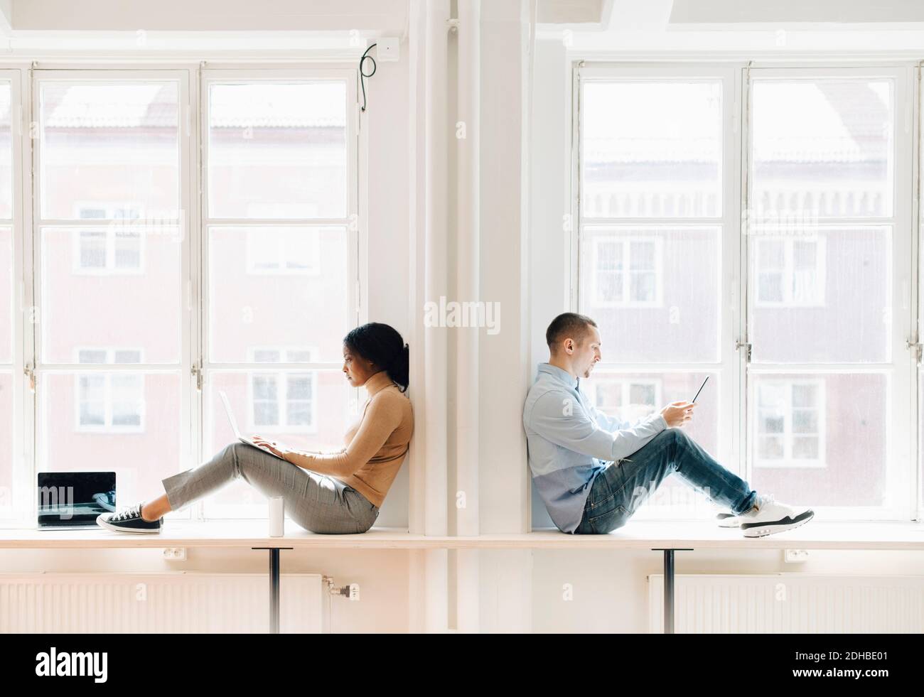 Full length side view of computer programmers working over technologies ...