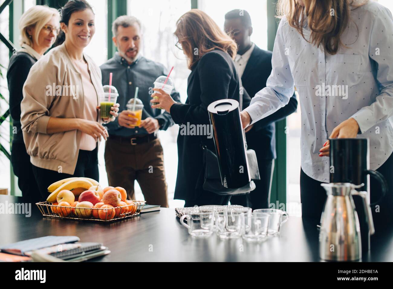 Business people having drinks and fruits during conference in office ...
