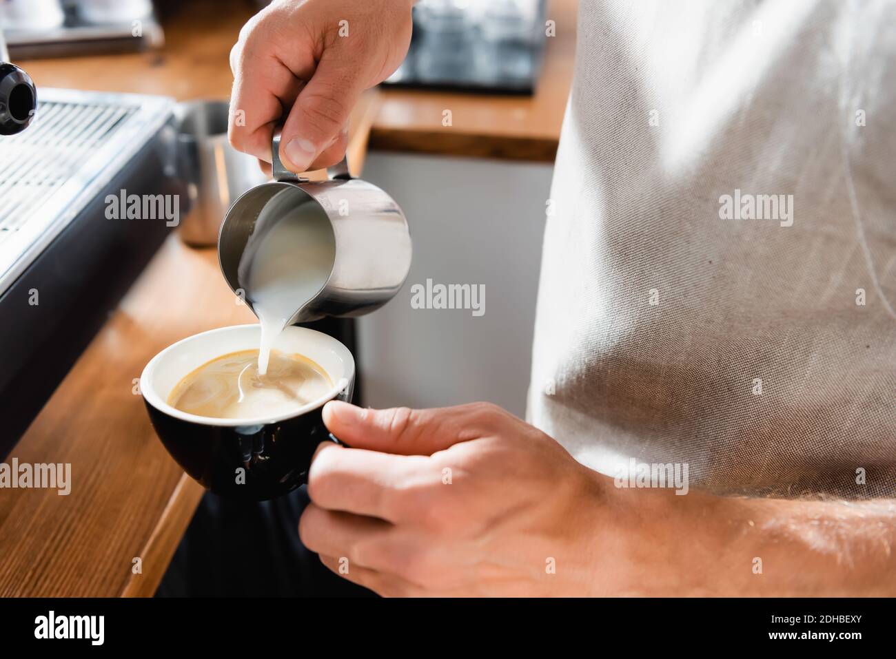 partial view of barista adding milk into cup of coffee Stock Photo - Alamy