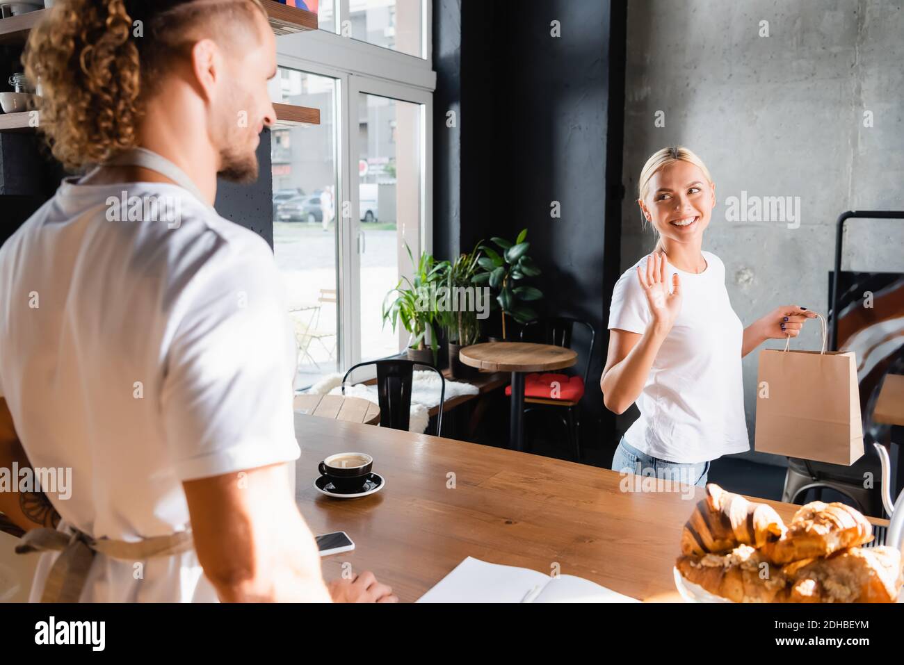 Smiling blonde woman barista waving hi-res stock photography and images ...