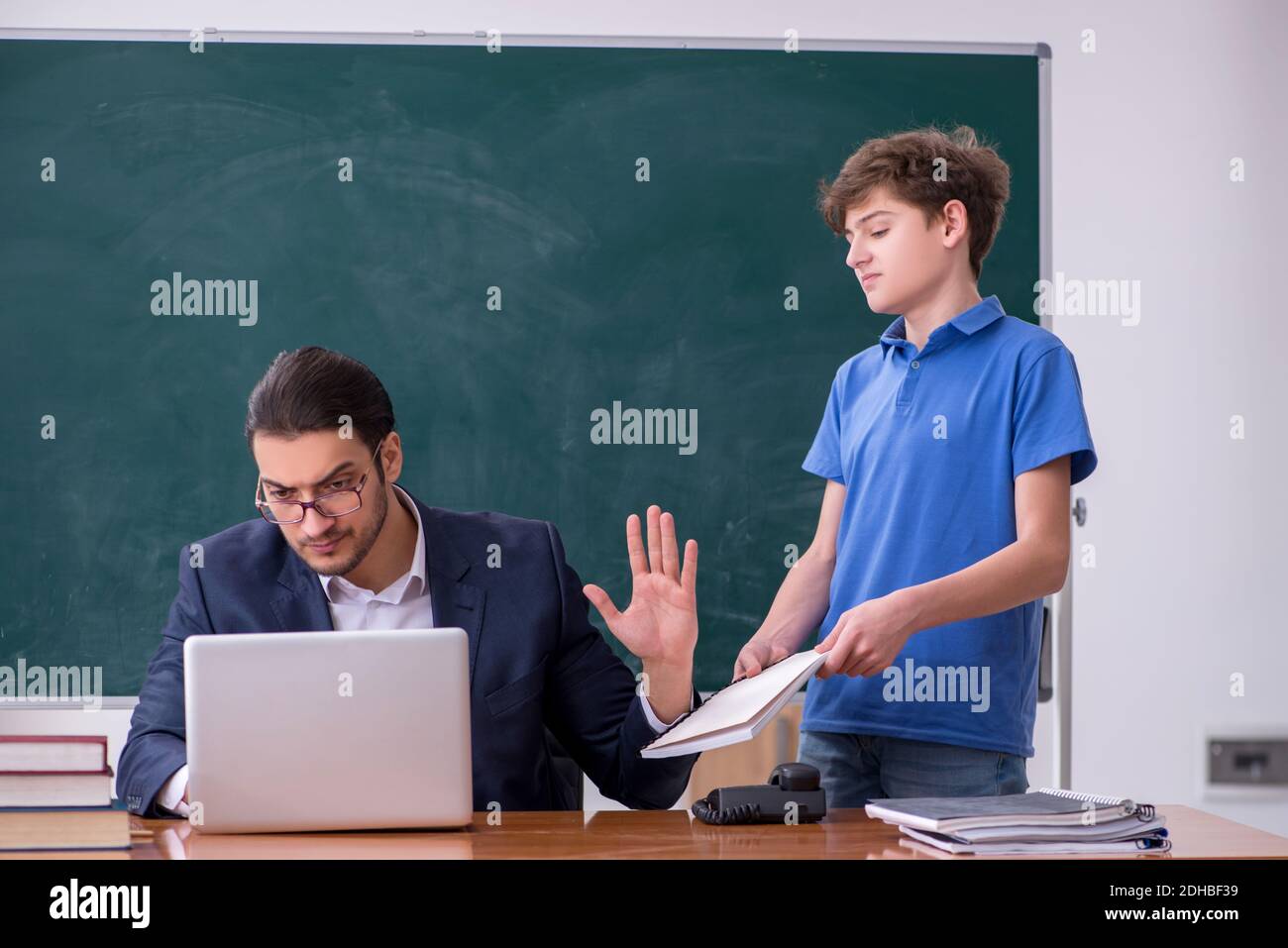 Young male teacher and schoolboy in the classroom Stock Photo - Alamy
