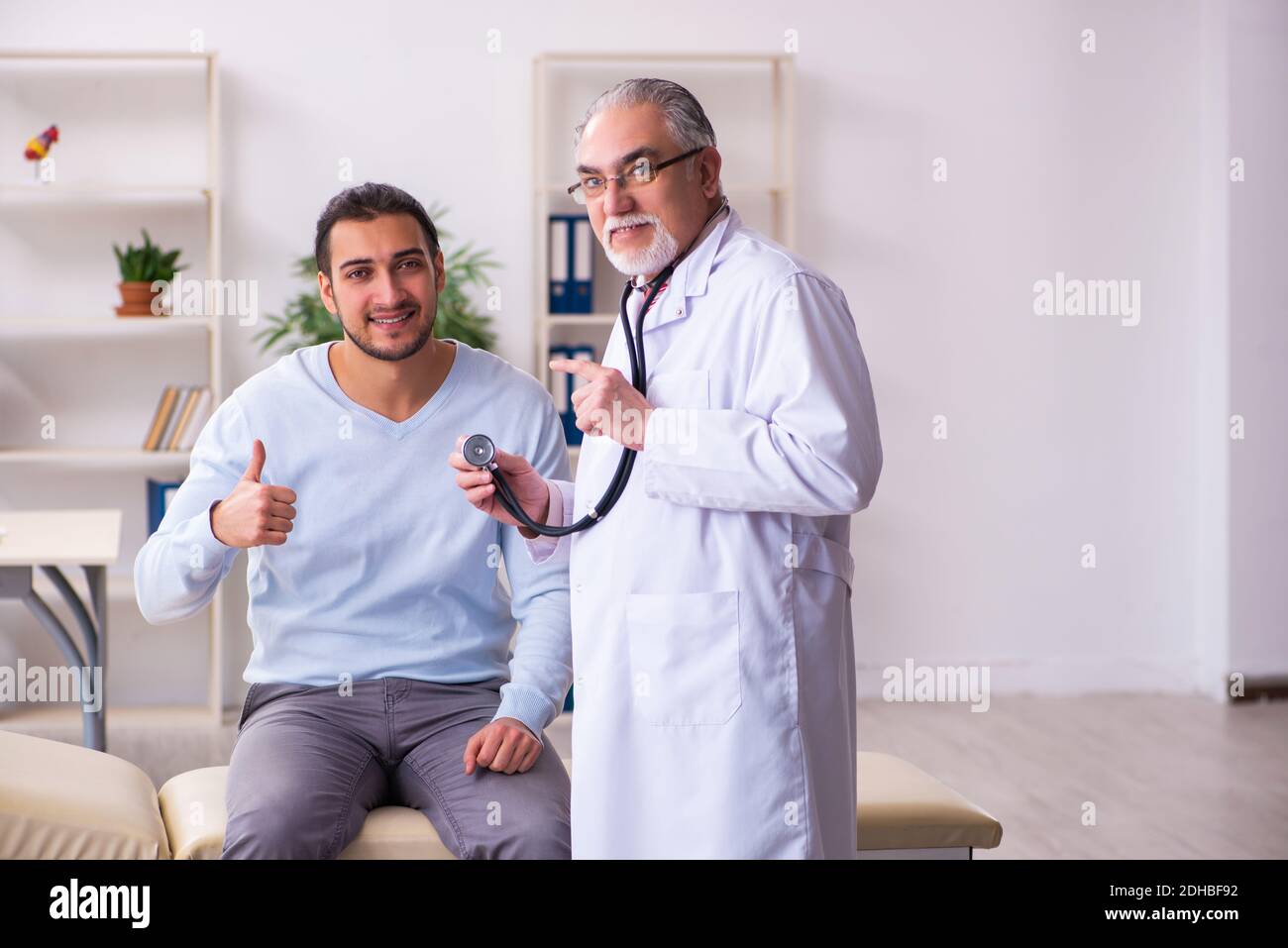 Young sick man visiting old doctor Stock Photo - Alamy