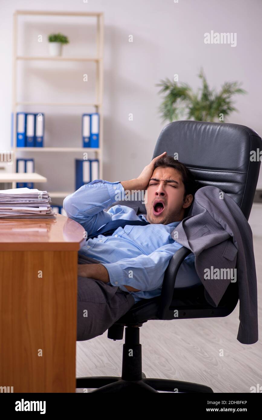 Young male employee sleeping in the office Stock Photo - Alamy