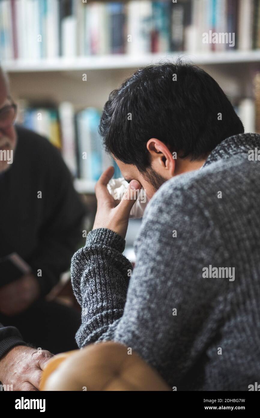 Doctor explaining sad male patient during therapy session Stock Photo ...