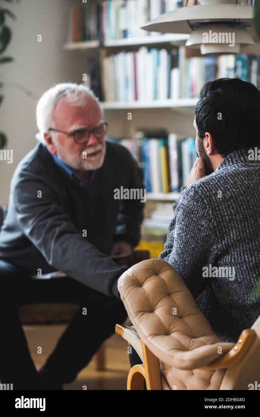 Senior therapist counseling patient during therapy session Stock Photo ...