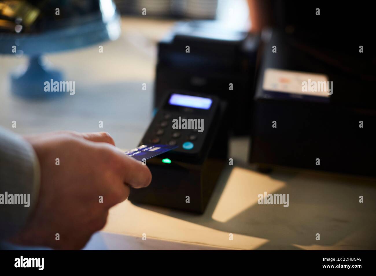 Cropped image of customer paying through credit card at checkout ...