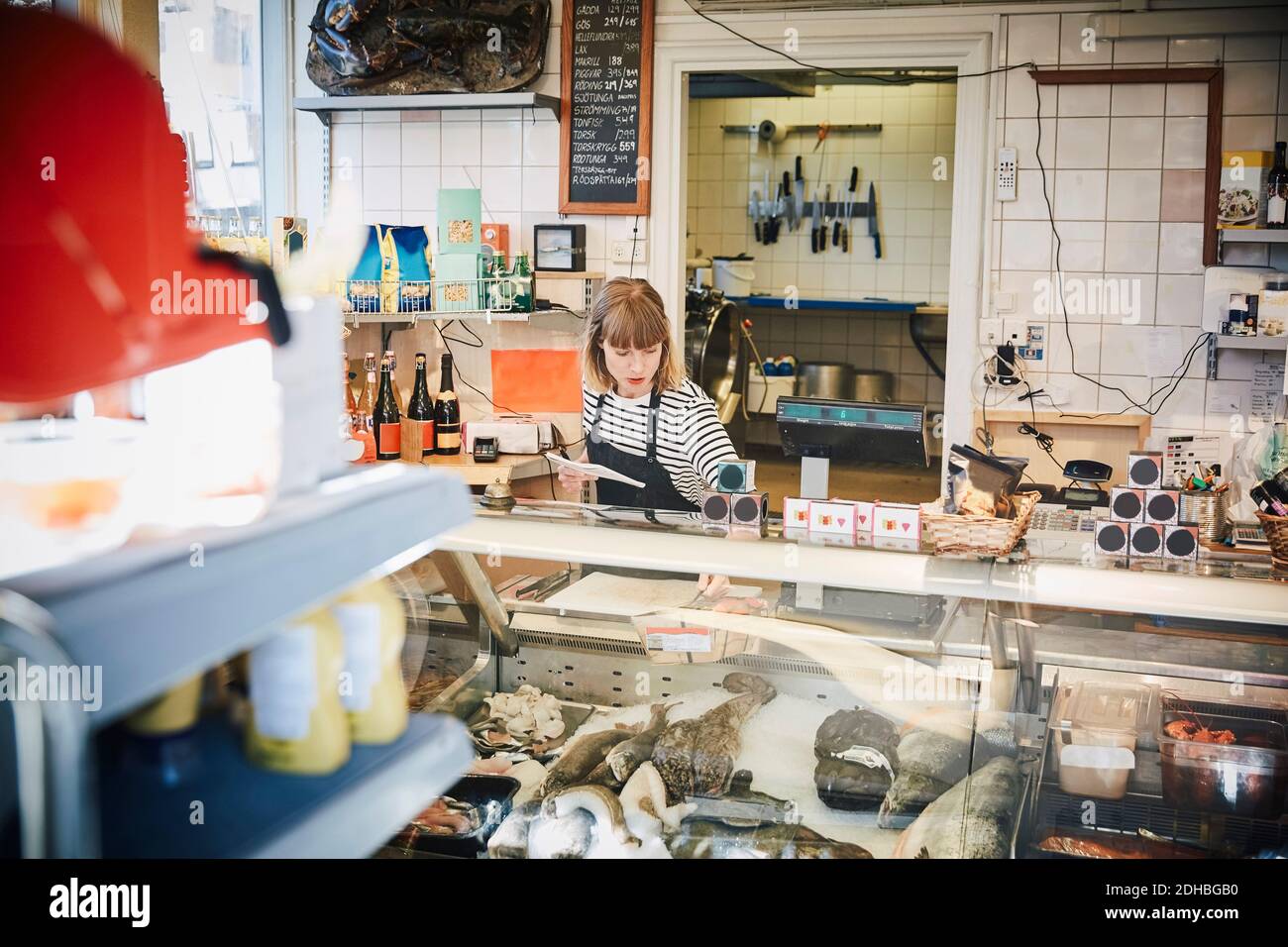 Female owner working at counter in store Stock Photo - Alamy