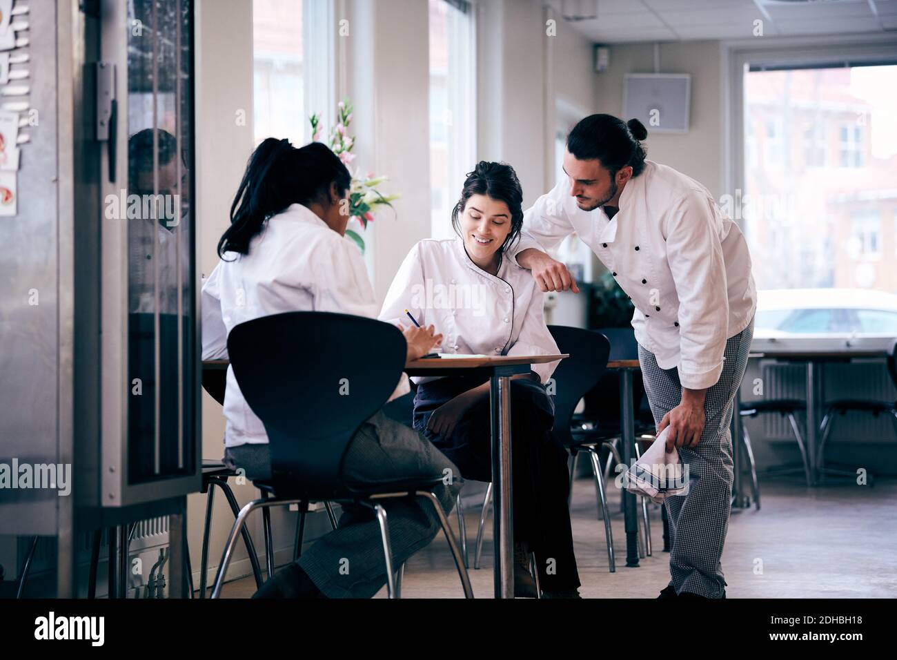 Multi-ethnic male and female chefs discussing menu in restaurant Stock ...