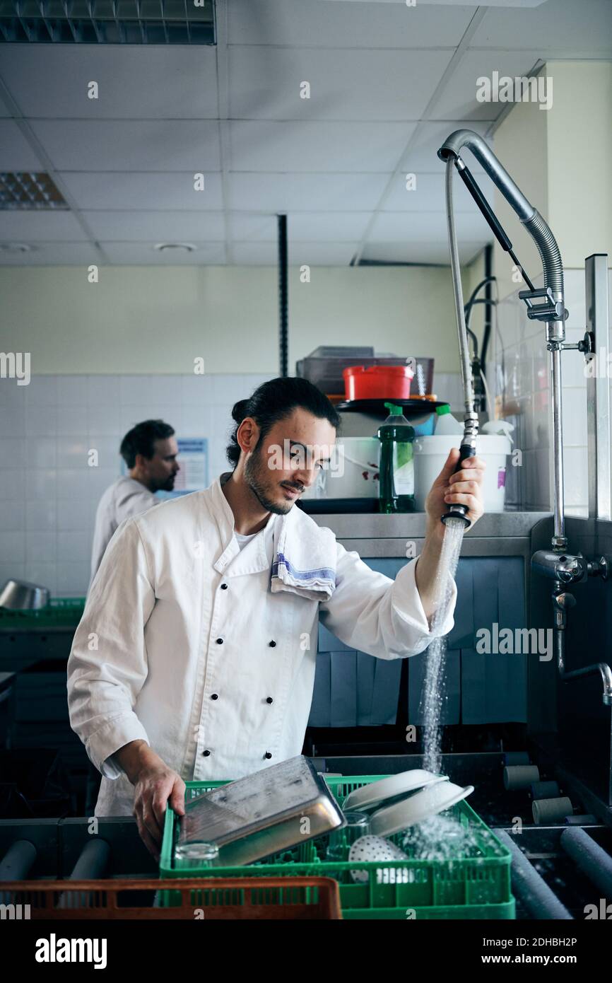 Chef spraying water on plates in commercial kitchen Stock Photo - Alamy