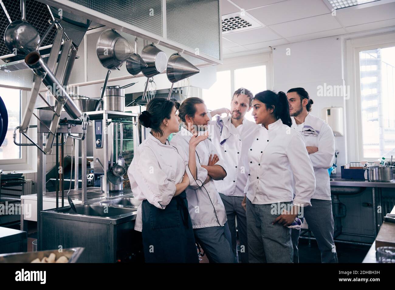 Chefs communicating in commercial kitchen Stock Photo - Alamy