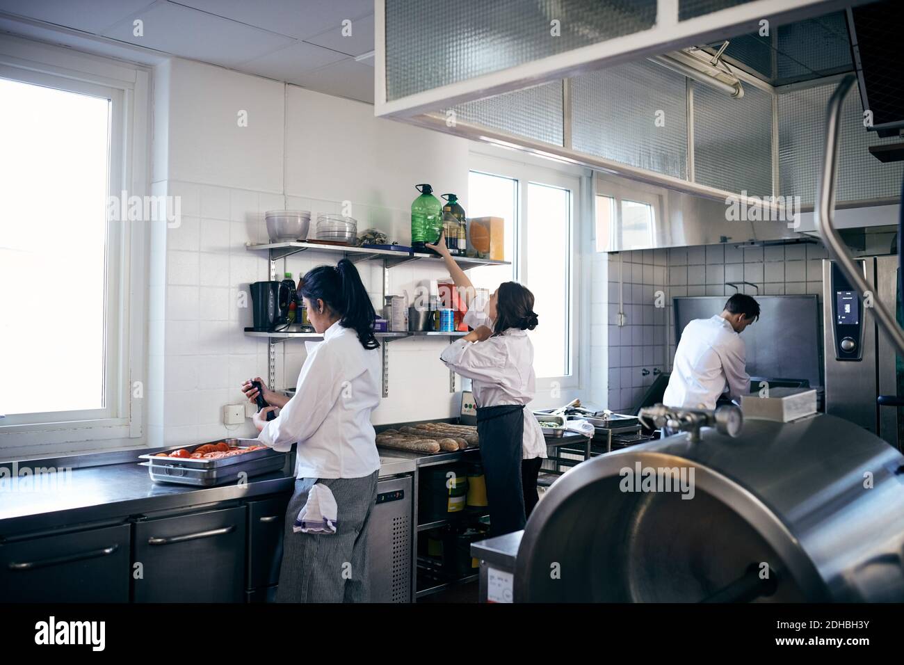 Female and male chefs working in commercial kitchen Stock Photo - Alamy