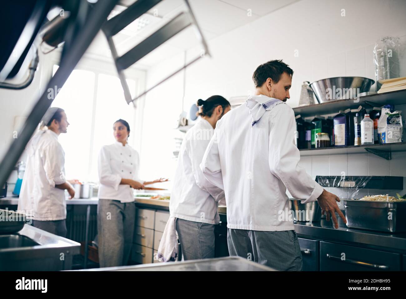Chefs preparing food at counter in commercial kitchen Stock Photo - Alamy