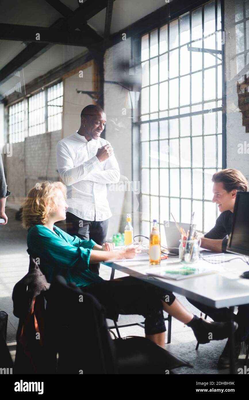 Smiling young male programmer giving presentation to team at new office ...