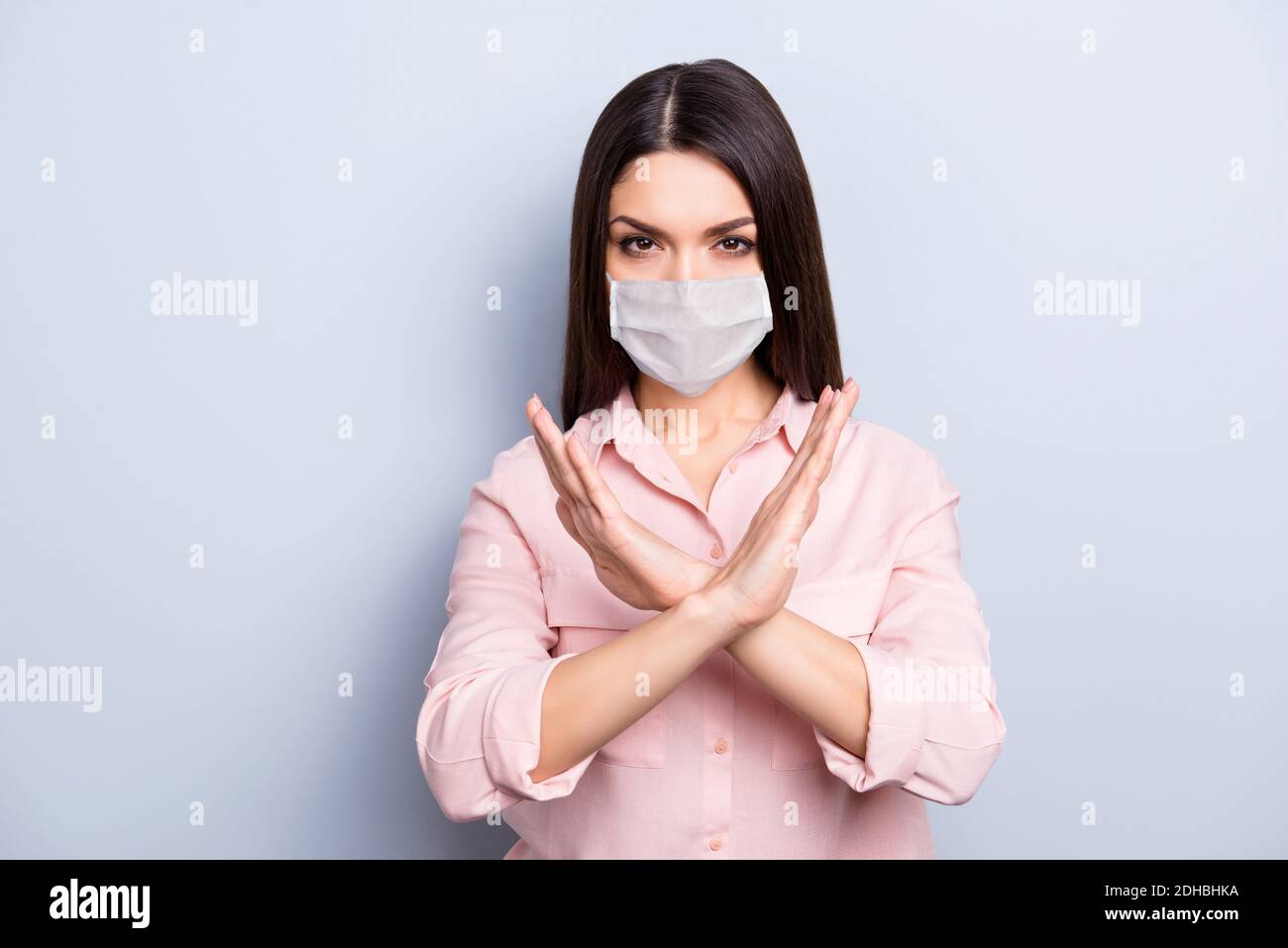 Portrait of attractive strict girl wearing safety mask showing stop ...