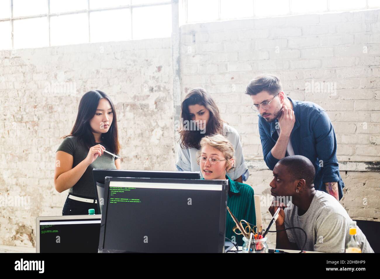 Confident young professionals planning while coding in computer at ...