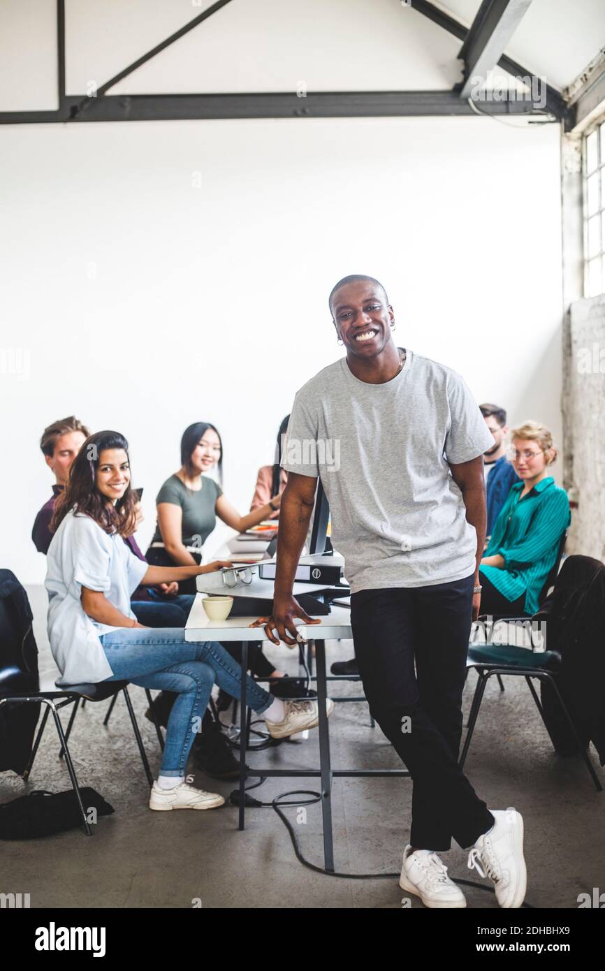 Portrait of smiling male IT expert while programmer team sitting at ...