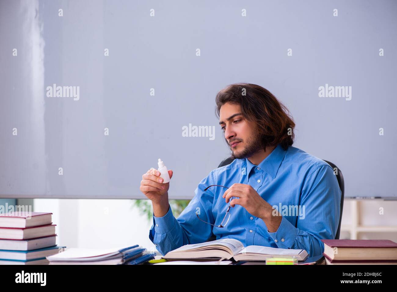 Young male teacher in the classroom Stock Photo - Alamy