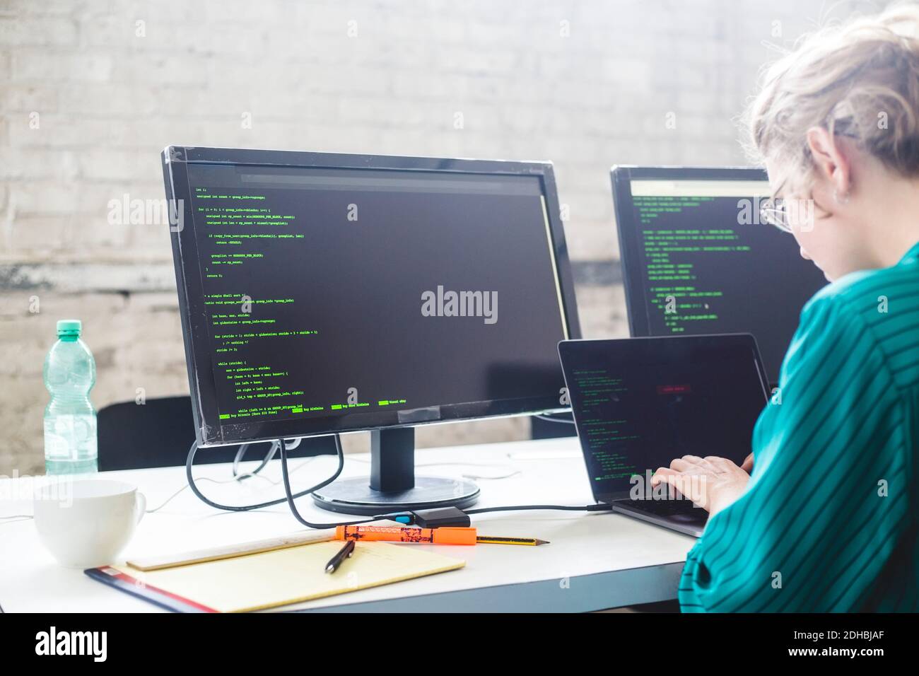 Side view of businesswoman working on start-up project while coding in ...