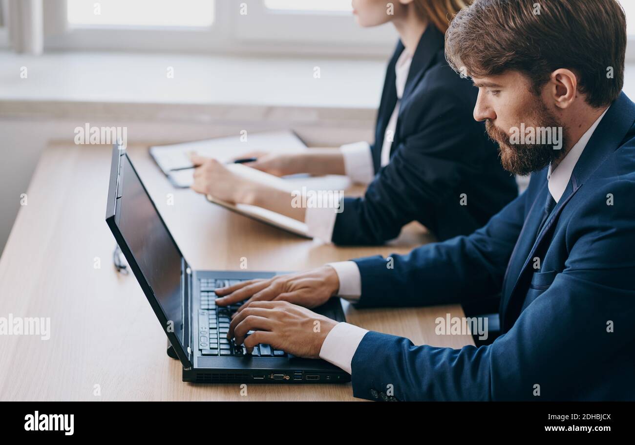 Work colleagues in suits working desk laptop office managers team Stock ...