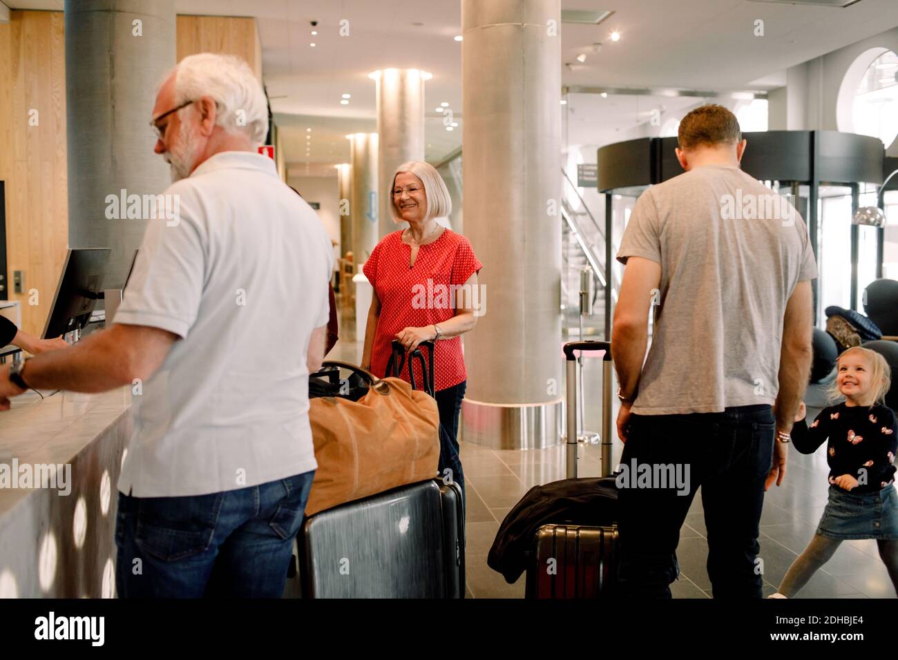Smiling family standing at reception in hotel Stock Photo - Alamy