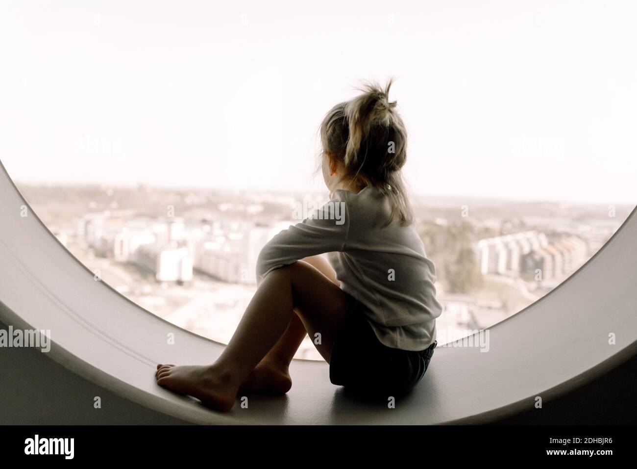 Full length of girl sitting on window sill in hotel room Stock Photo ...