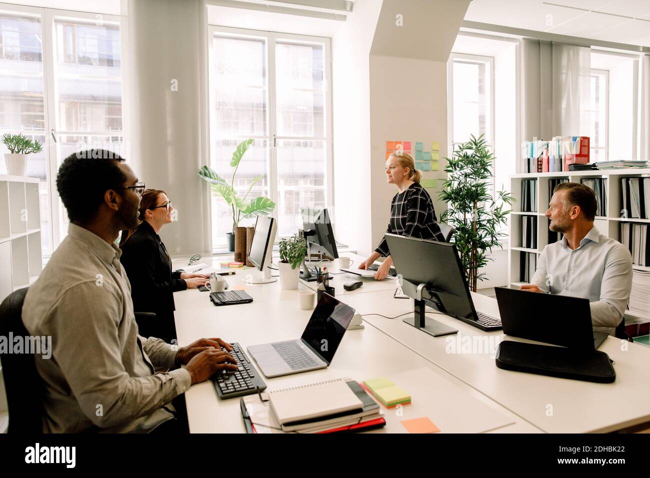 Business colleagues planning sales strategies at desk in office Stock ...
