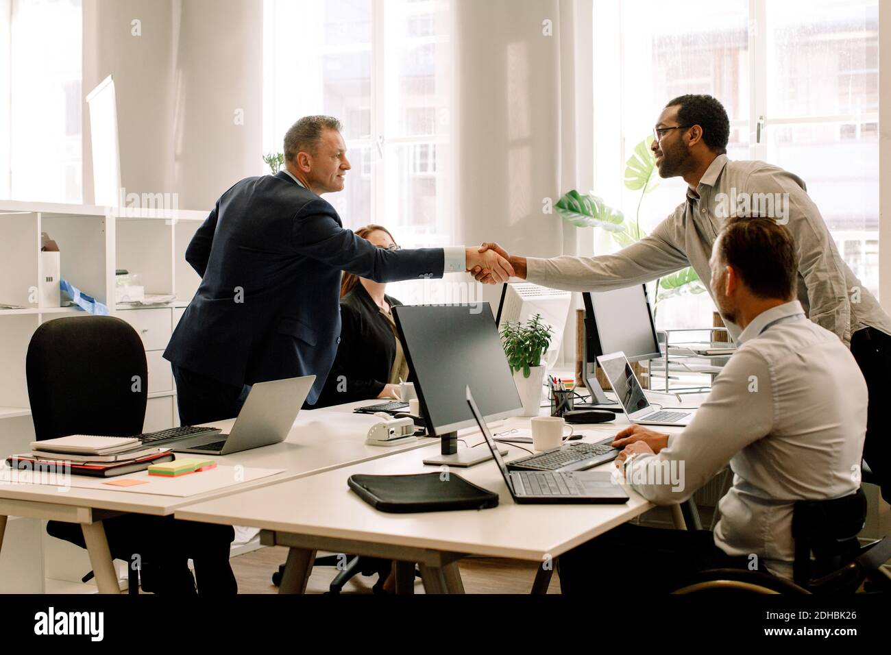 Businessmen shaking hands during sales meeting in office Stock Photo ...