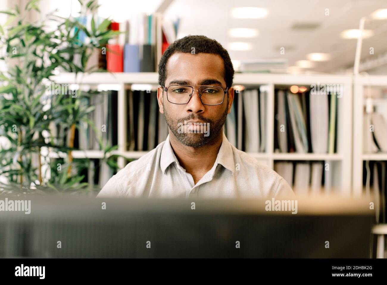 Male business professional wearing eyeglasses while working in office ...