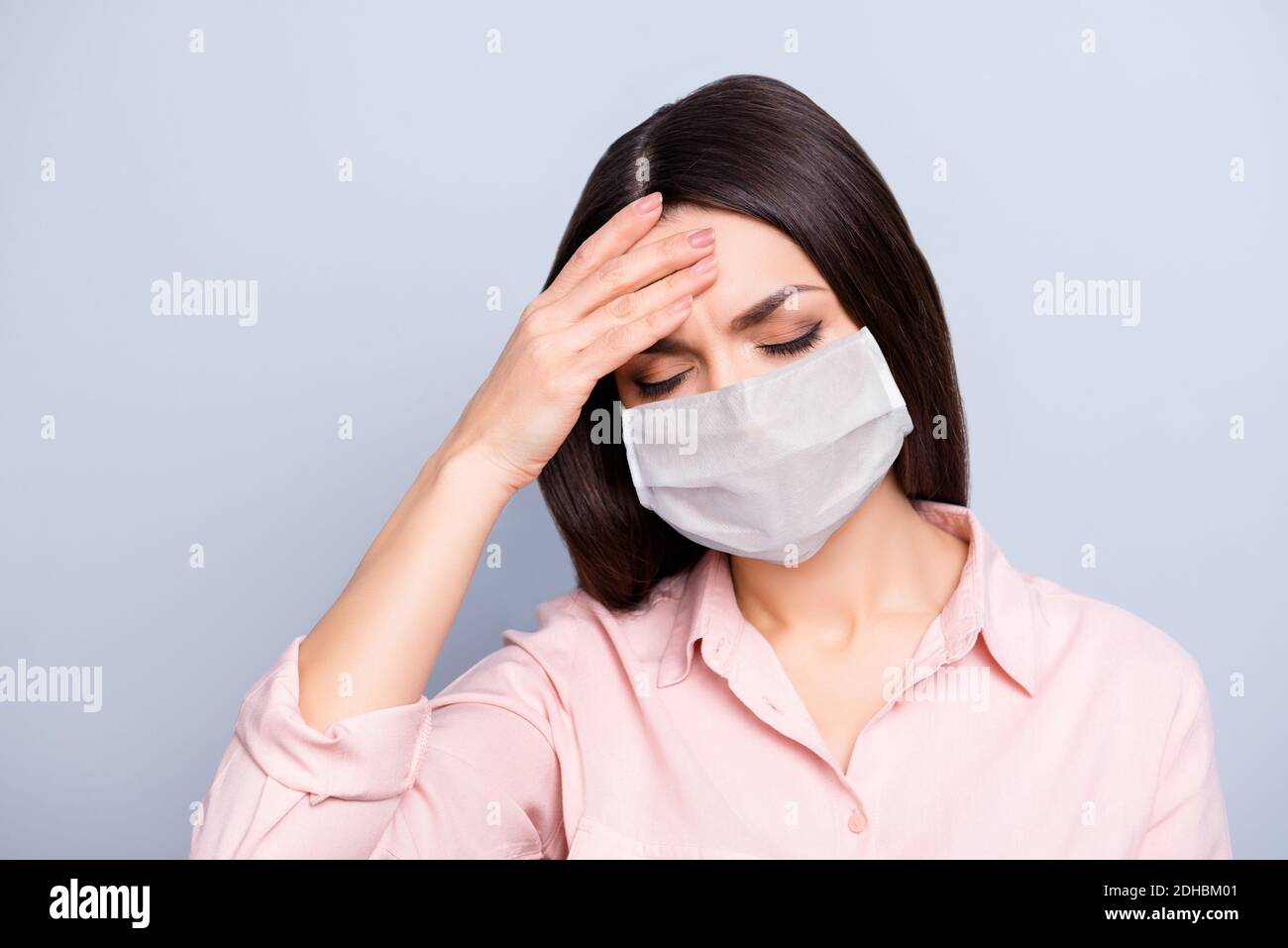 Close-up portrait of attractive sick girl wearing safety mask touching ...