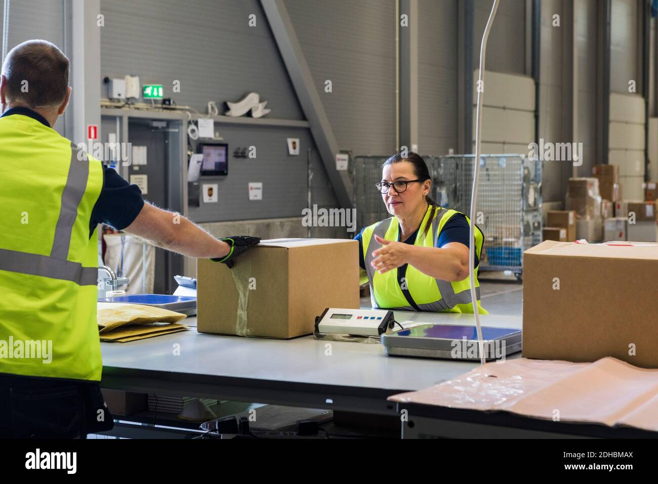 Coworkers packing merchandise on desk at warehouse Stock Photo - Alamy
