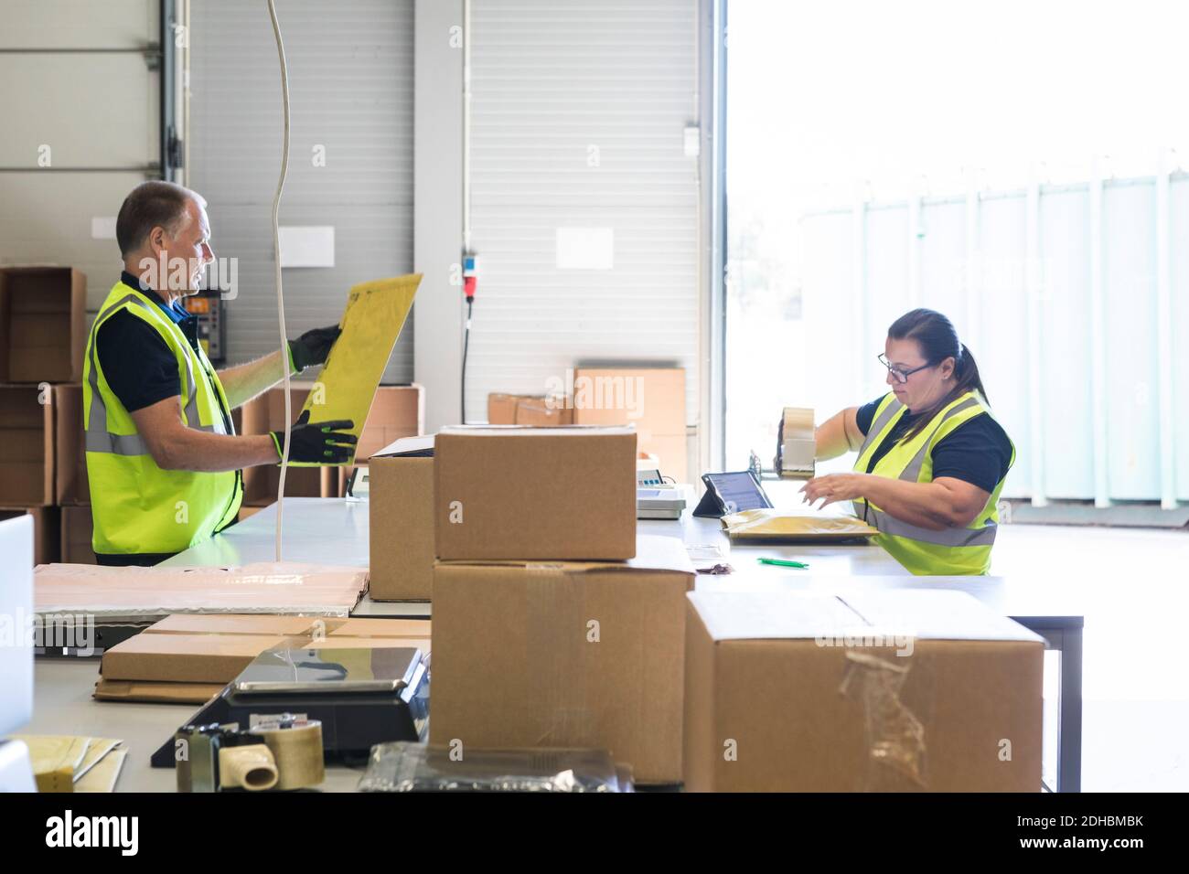 Coworkers packing merchandise on desk at distribution warehouse Stock ...