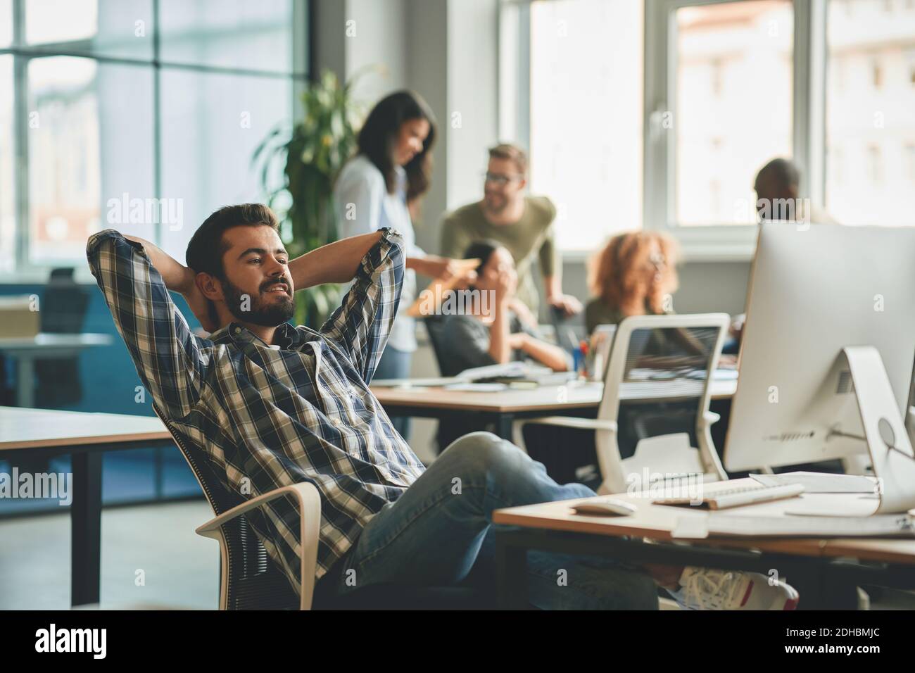 Relaxed male office worker not feeling the pressure at work Stock Photo ...