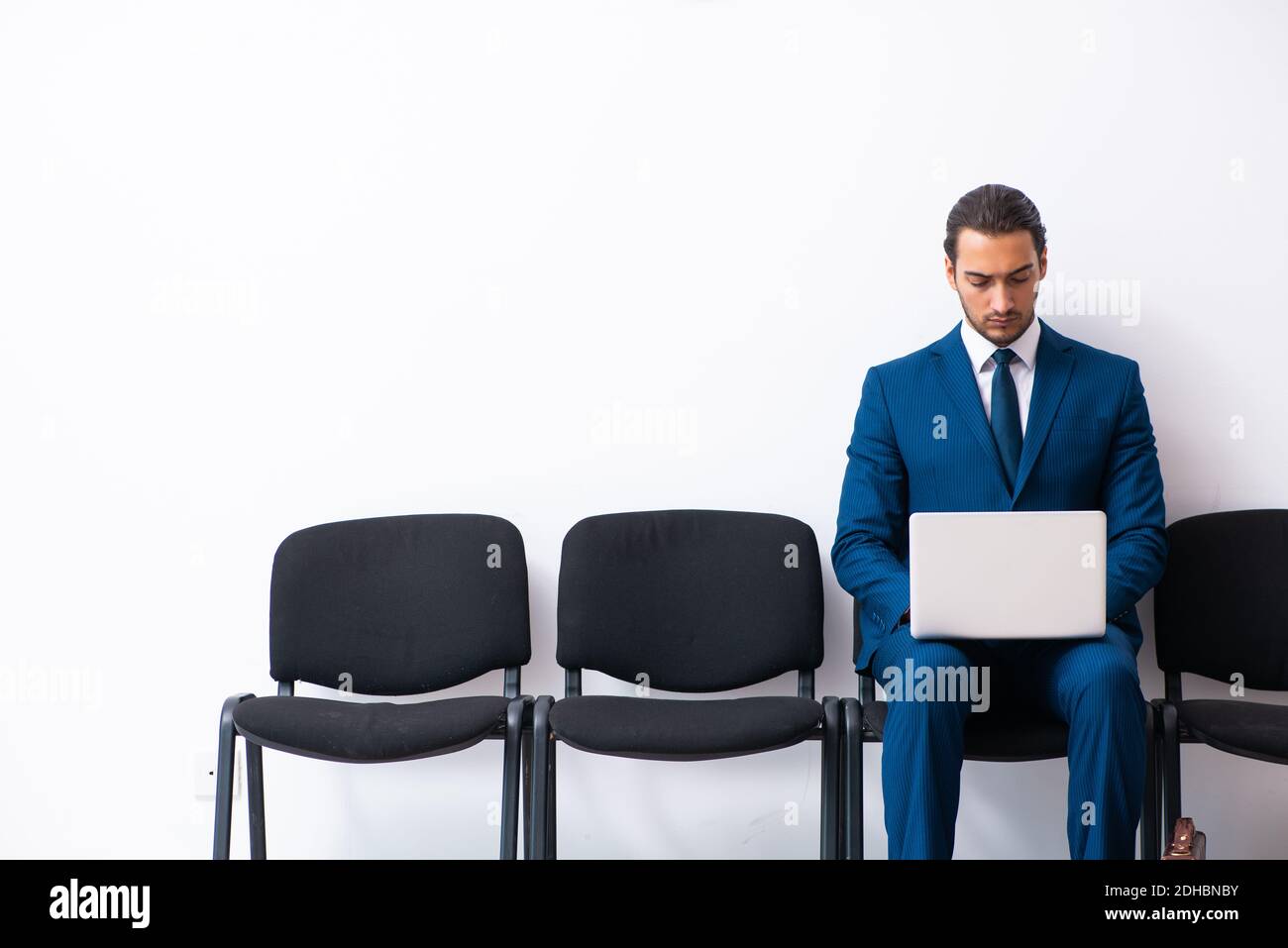 Young businessman waiting for an interview at hall Stock Photo - Alamy