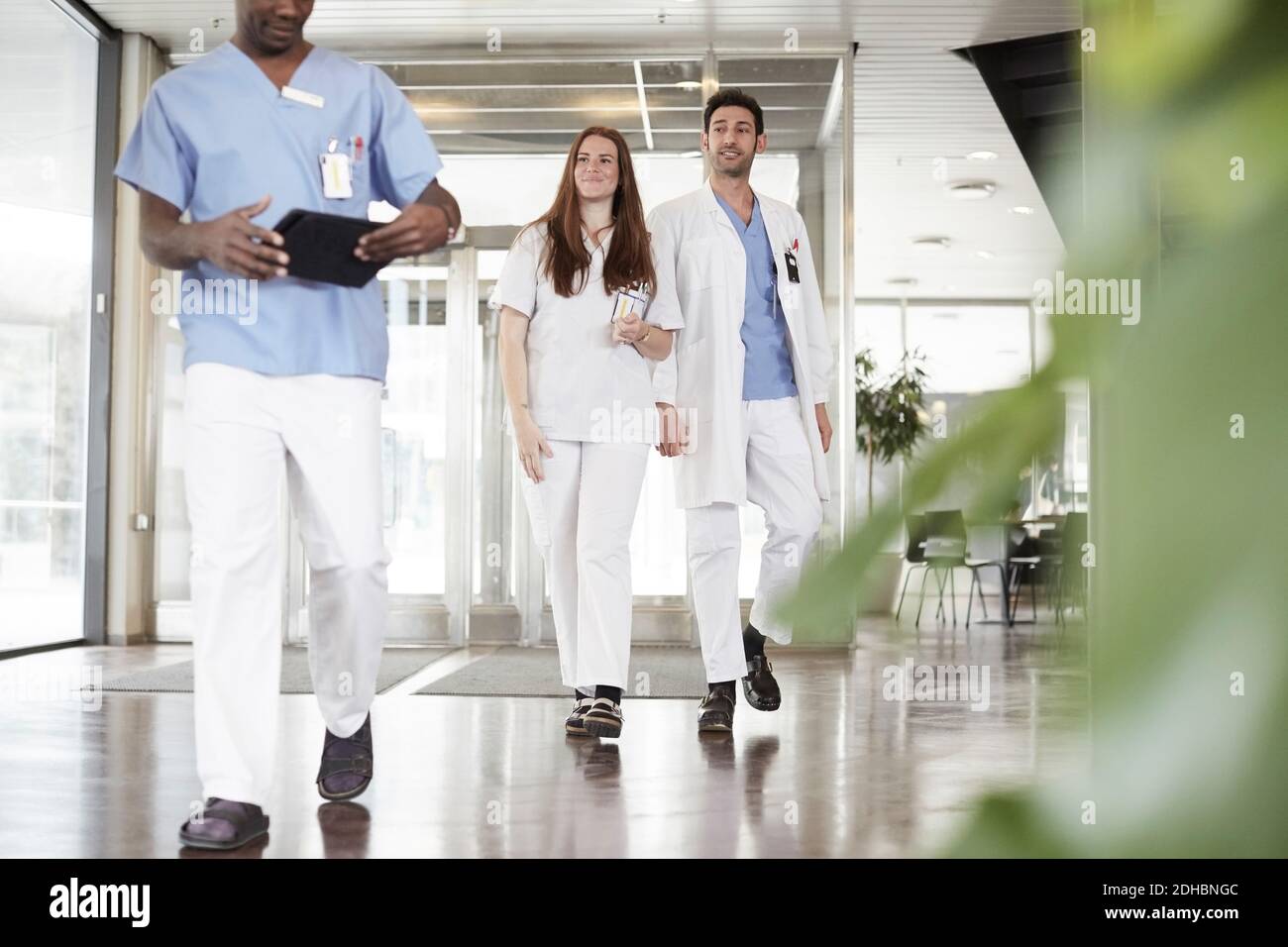 Confident healthcare workers walking in lobby at hospital Stock Photo ...