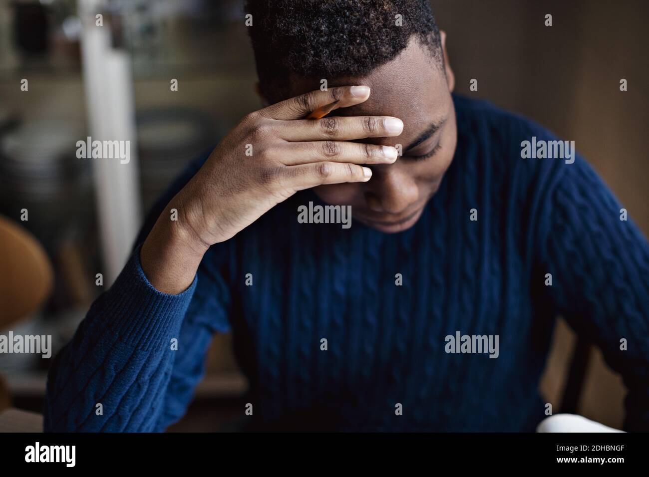 Stressed teenage boy with head in hand studying at home Stock Photo - Alamy