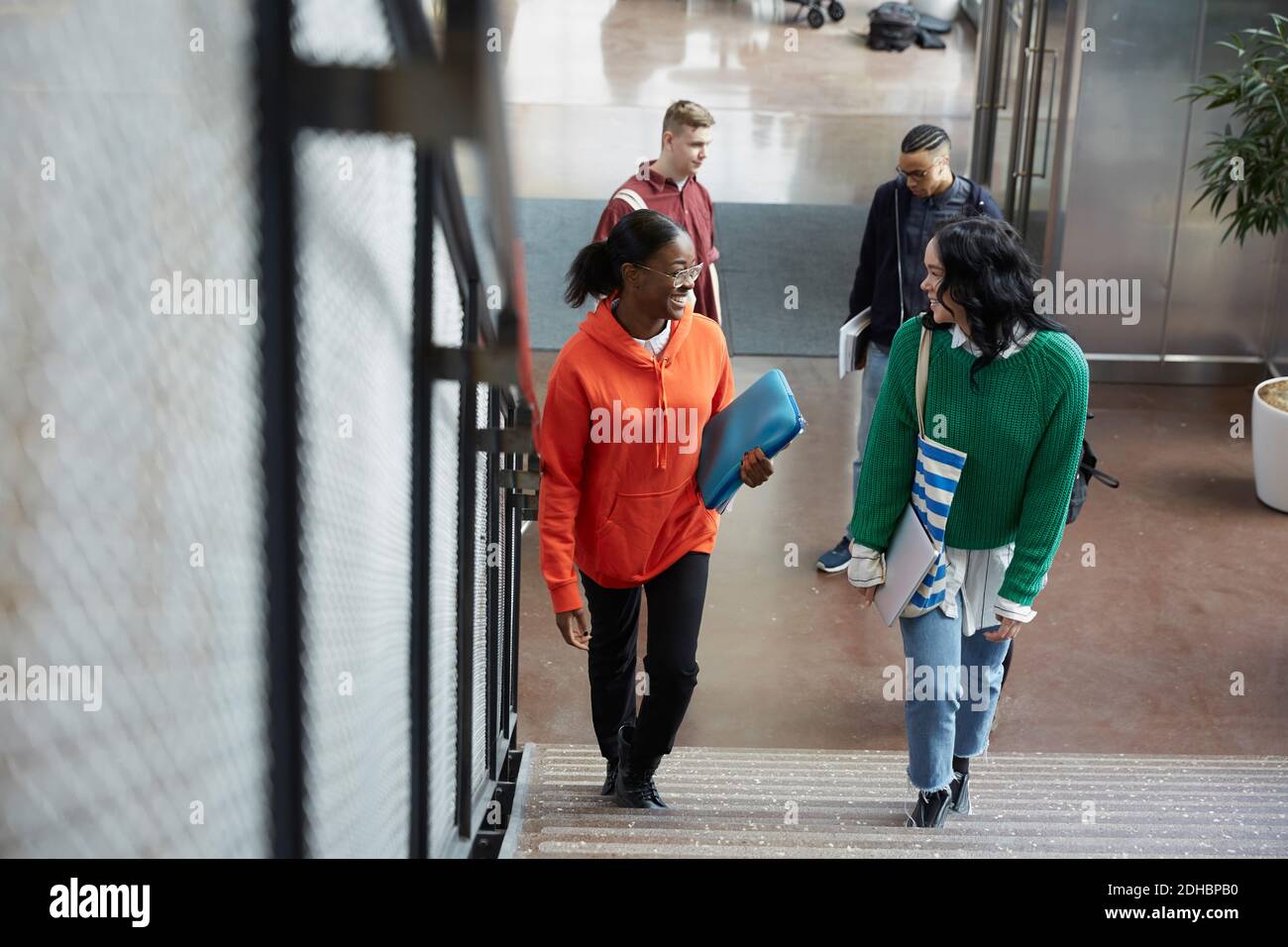 High angle view of students talking while moving on steps at university ...