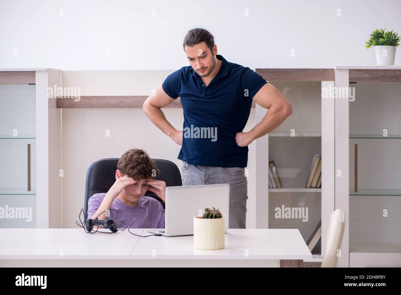Young father and schoolboy playing computer games at home Stock Photo ...