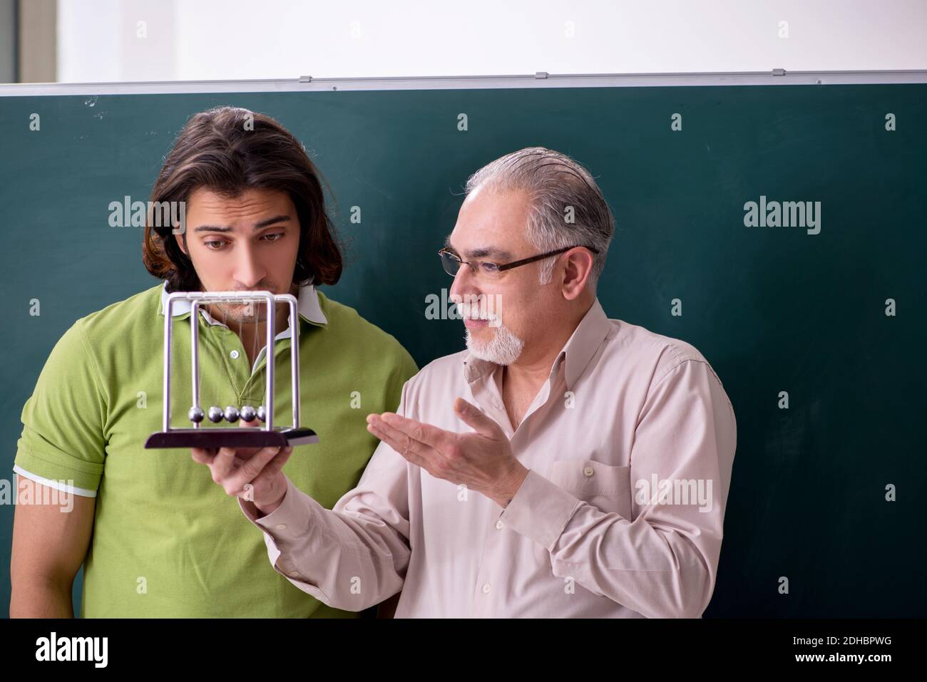 Old professor physicist and young student in the classroom Stock Photo ...