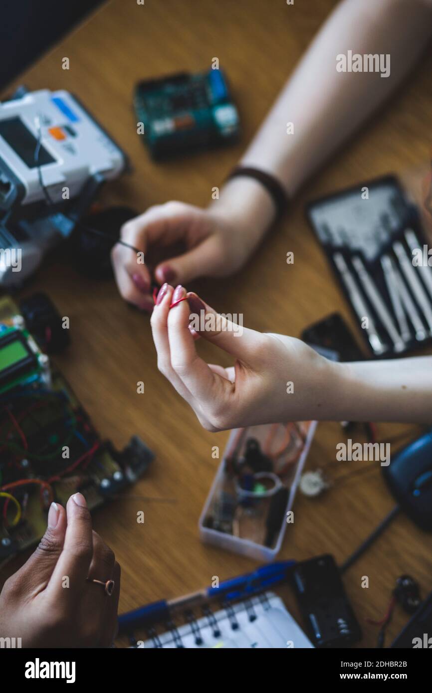 High angle view of female students preparing science project at desk in ...