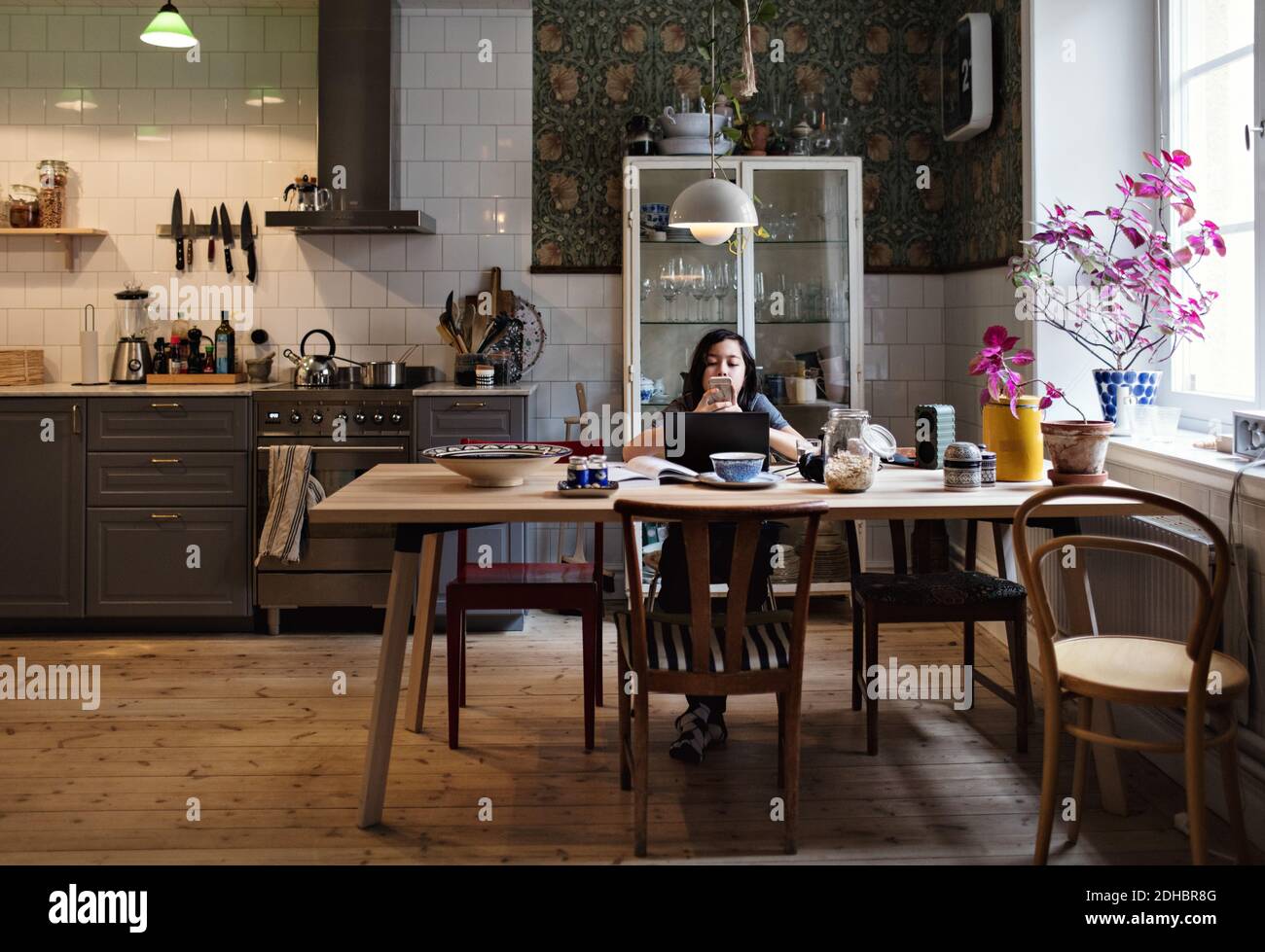 Full length of distracted boy using social media while sitting at home ...