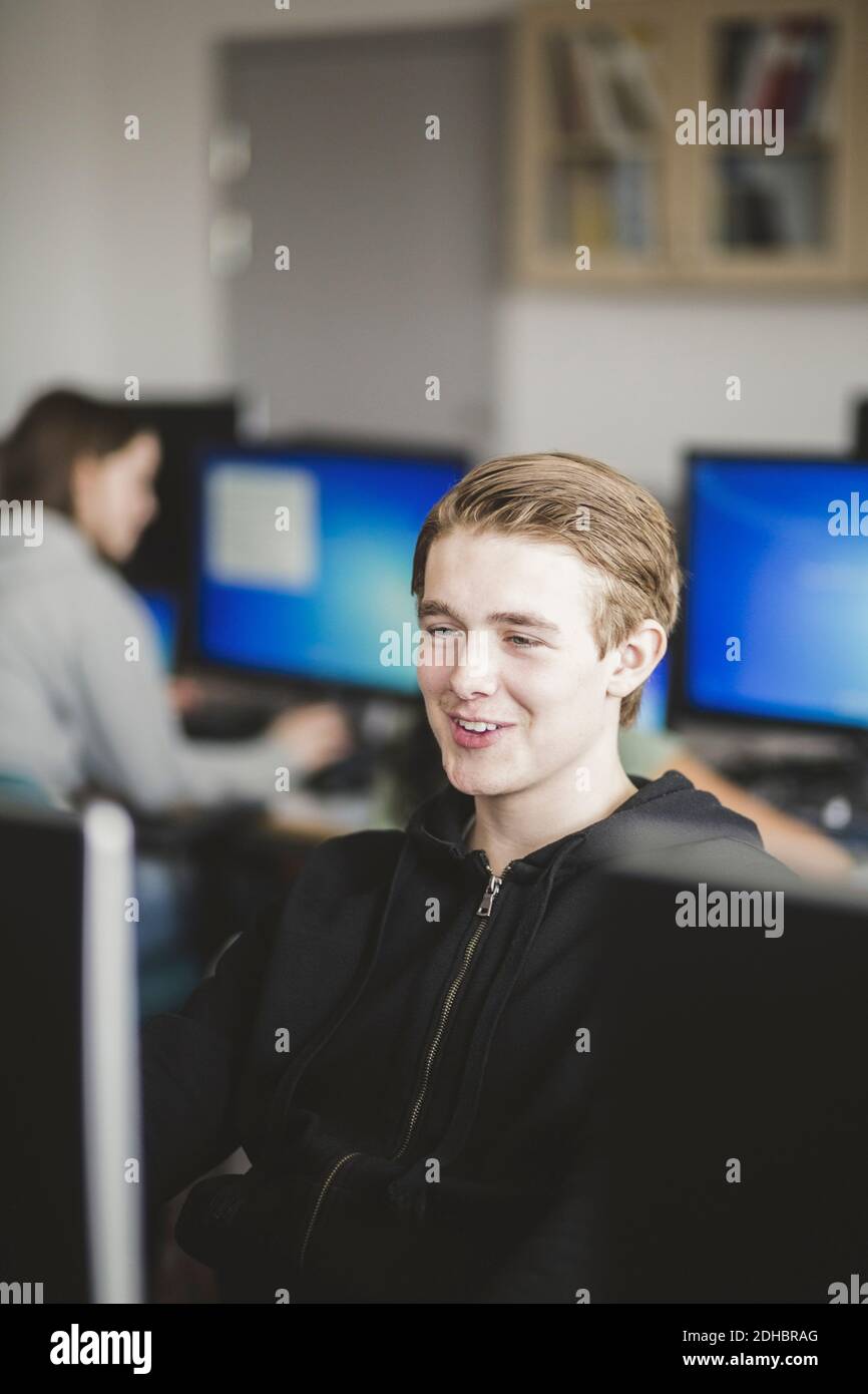 Smiling high school teenage student using computer in classroom Stock ...